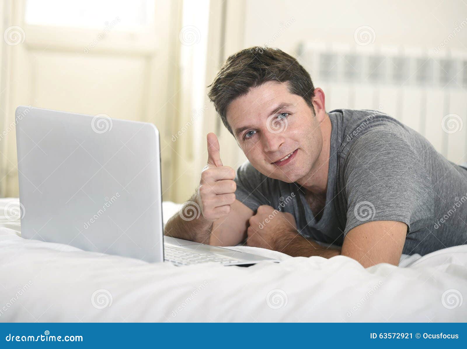 Young Attractive Man Lying on Bed or Couch Enjoying Social Networking ...