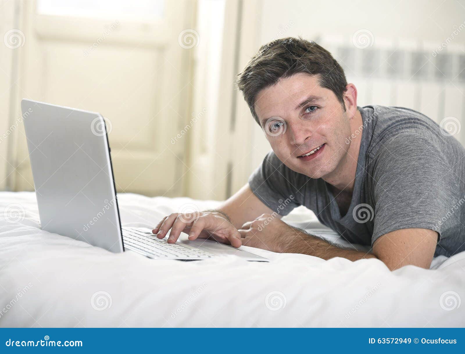 Young Attractive Man Lying on Bed or Couch Enjoying Social Networking ...