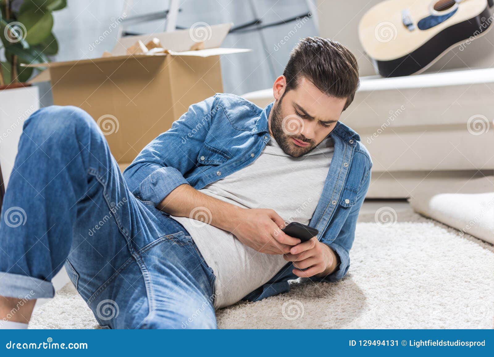 Man on Floor Using Smartphone Stock Image - Image of indoors, happy ...