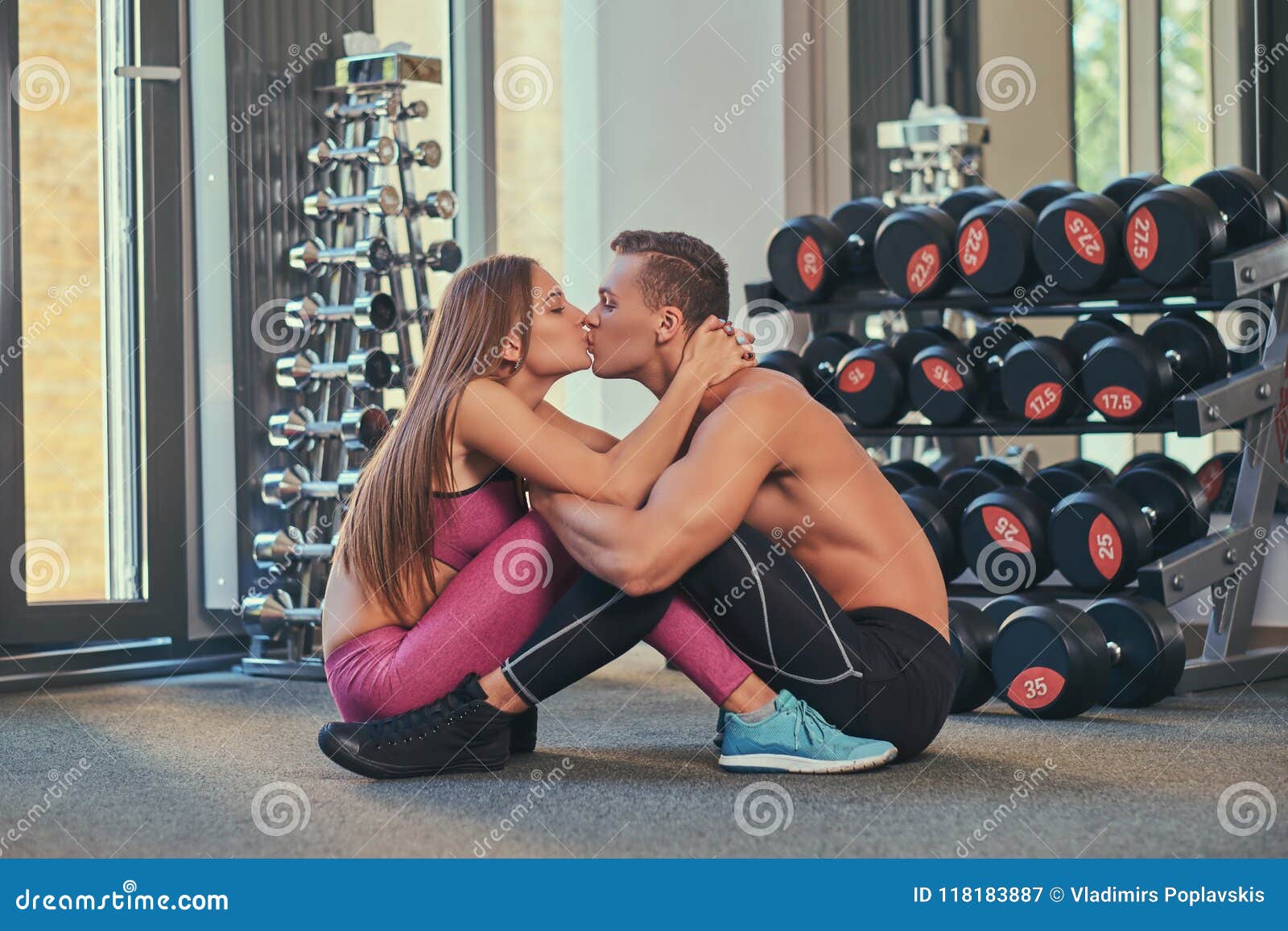 Young Attractive Sporty Couple Sitting Opposite Each Other On The Floor
