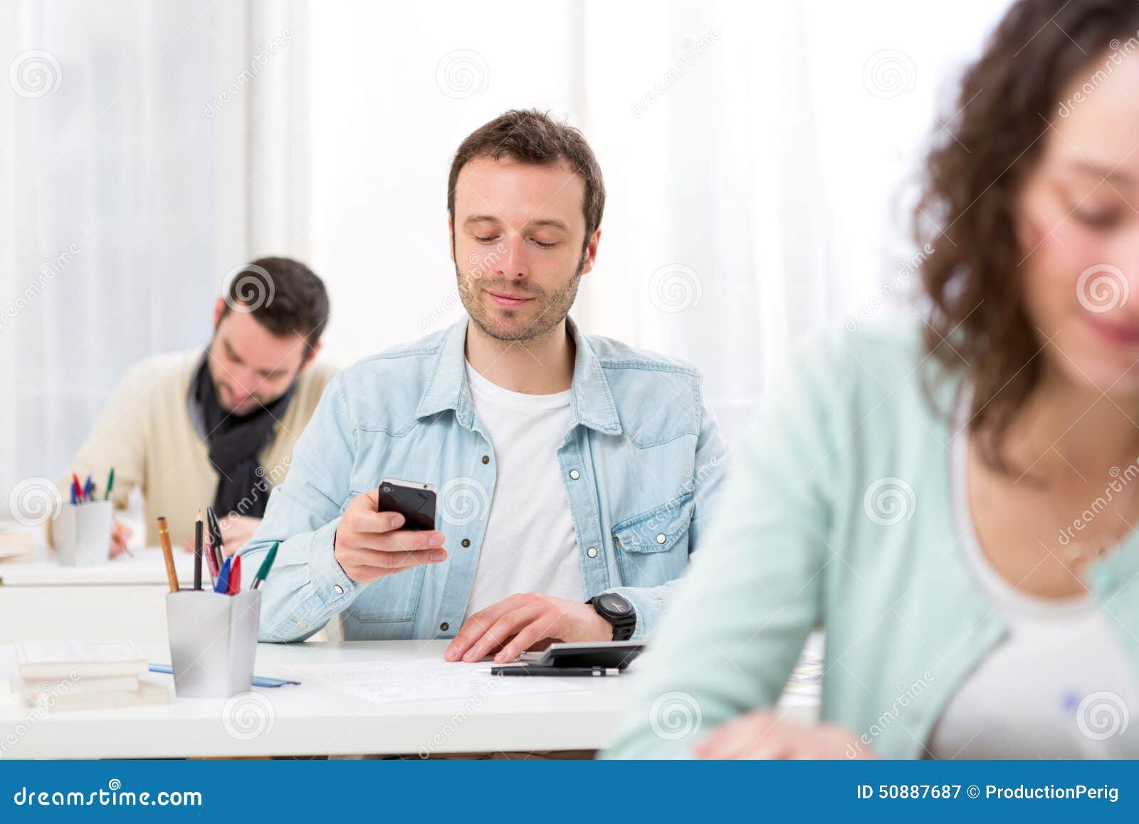 Young Attractive Student Using His Mobile during Classes Stock Image ...