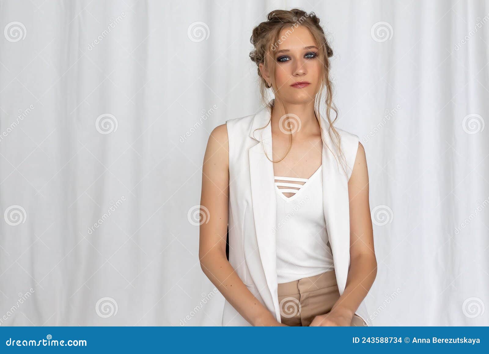 Young Attractive Woman In White Clothes Posing On Abstract Pale