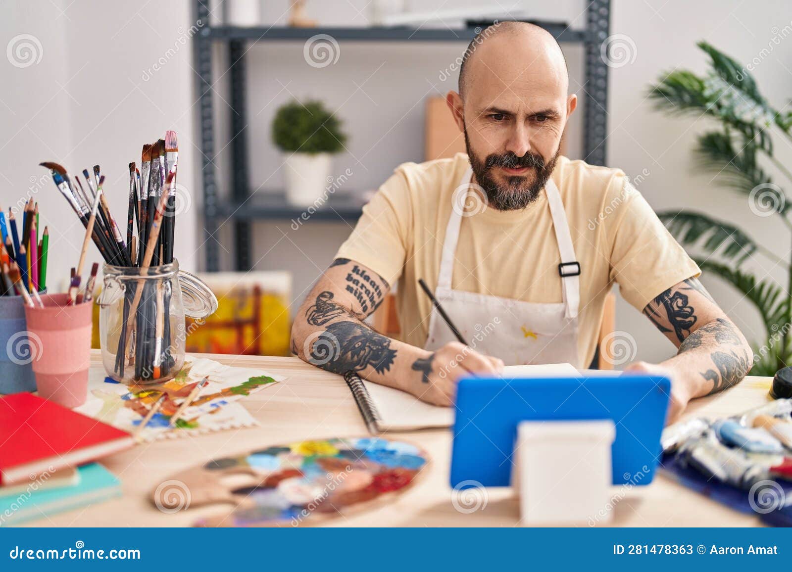 Young Bald Man Artist Drawing on Notebook Looking Touchpad at Art ...