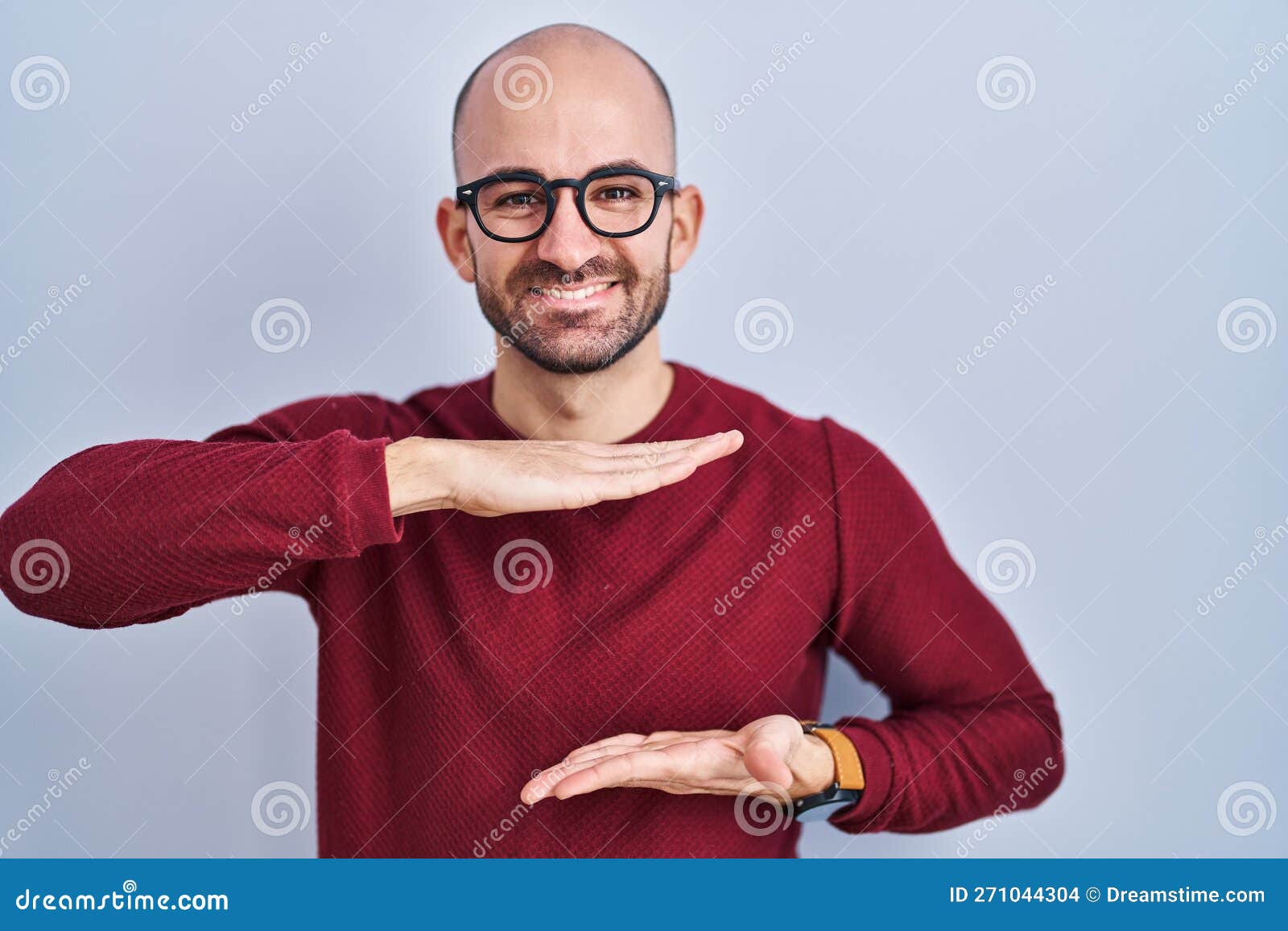 Young Bald Man With Beard Standing Over White Background Wearing Glasses Gesturing With Hands