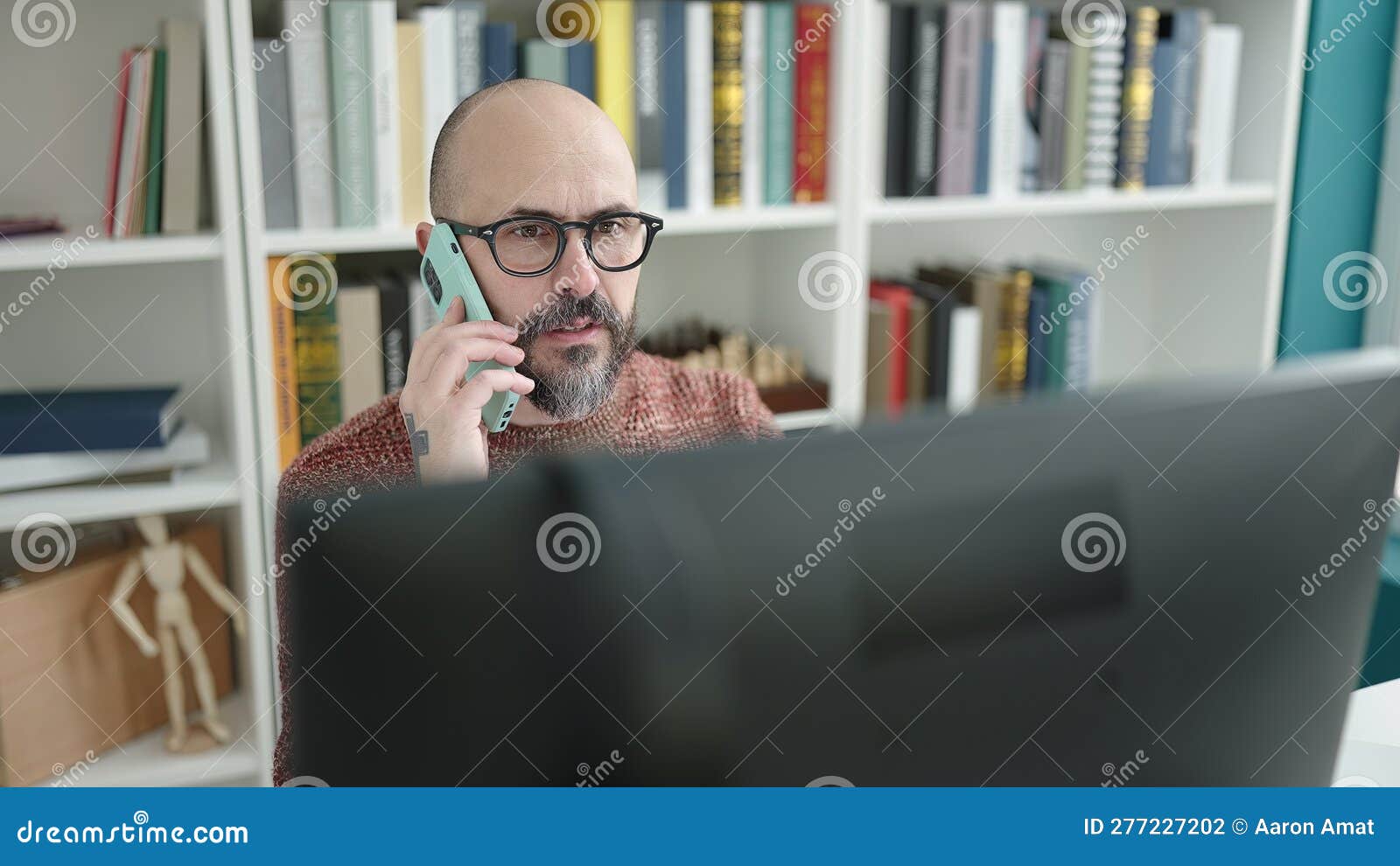 Young Bald Man Student Using Computer Talking on Smartphone at ...