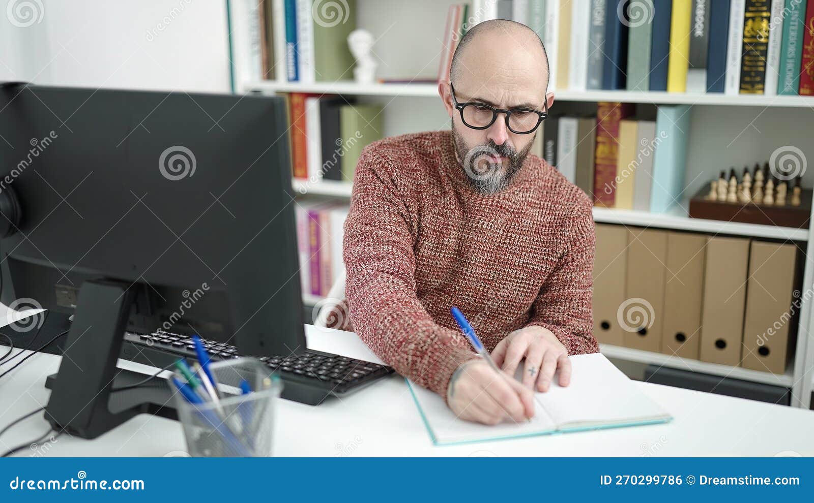 Young Bald Man Student Using Computer Writing on Notebook at University ...