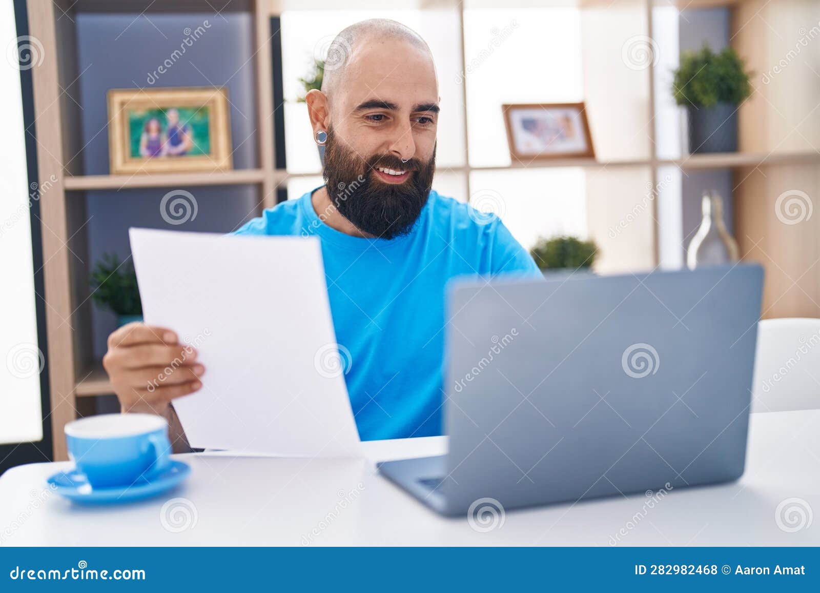 Young Bald Man Using Laptop Reading Paper at Home Stock Photo - Image ...