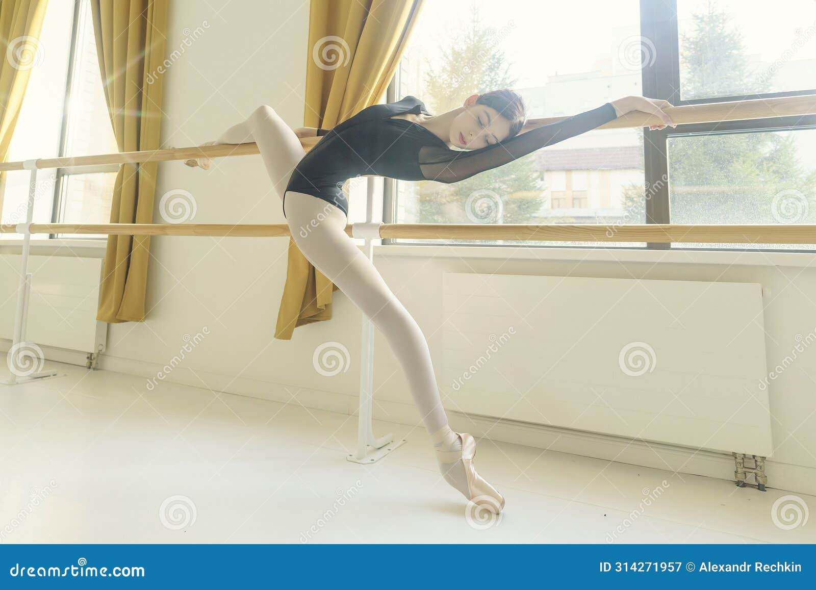 Young Ballerina in a Dance Class at a Ballet Machine Does Stretching ...