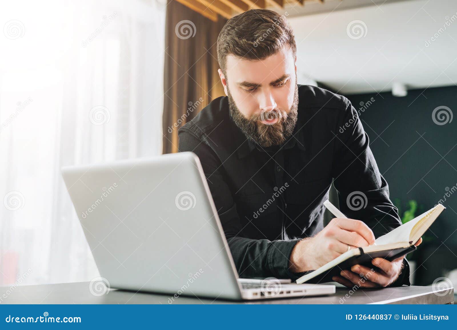 Businessman is Standing Near Computer, Working on Laptop, Making Notes ...