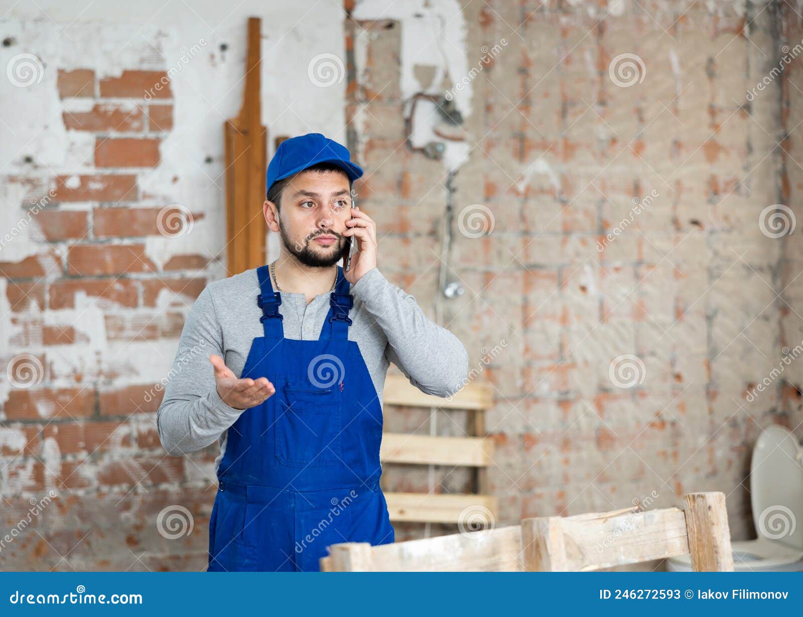 Young Bearded Contractor Talking on Phone at Construction Site Indoors ...