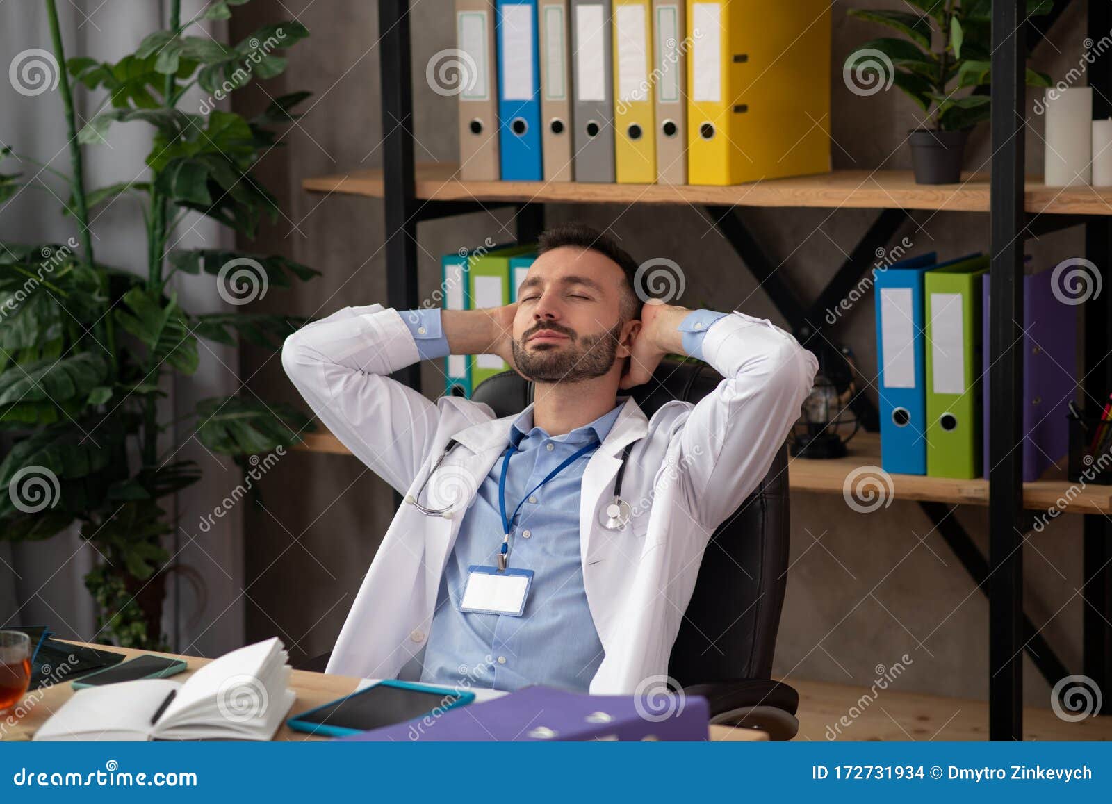 Young Bearded Doctor in a White Robe Stretching Stock Photo - Image of ...