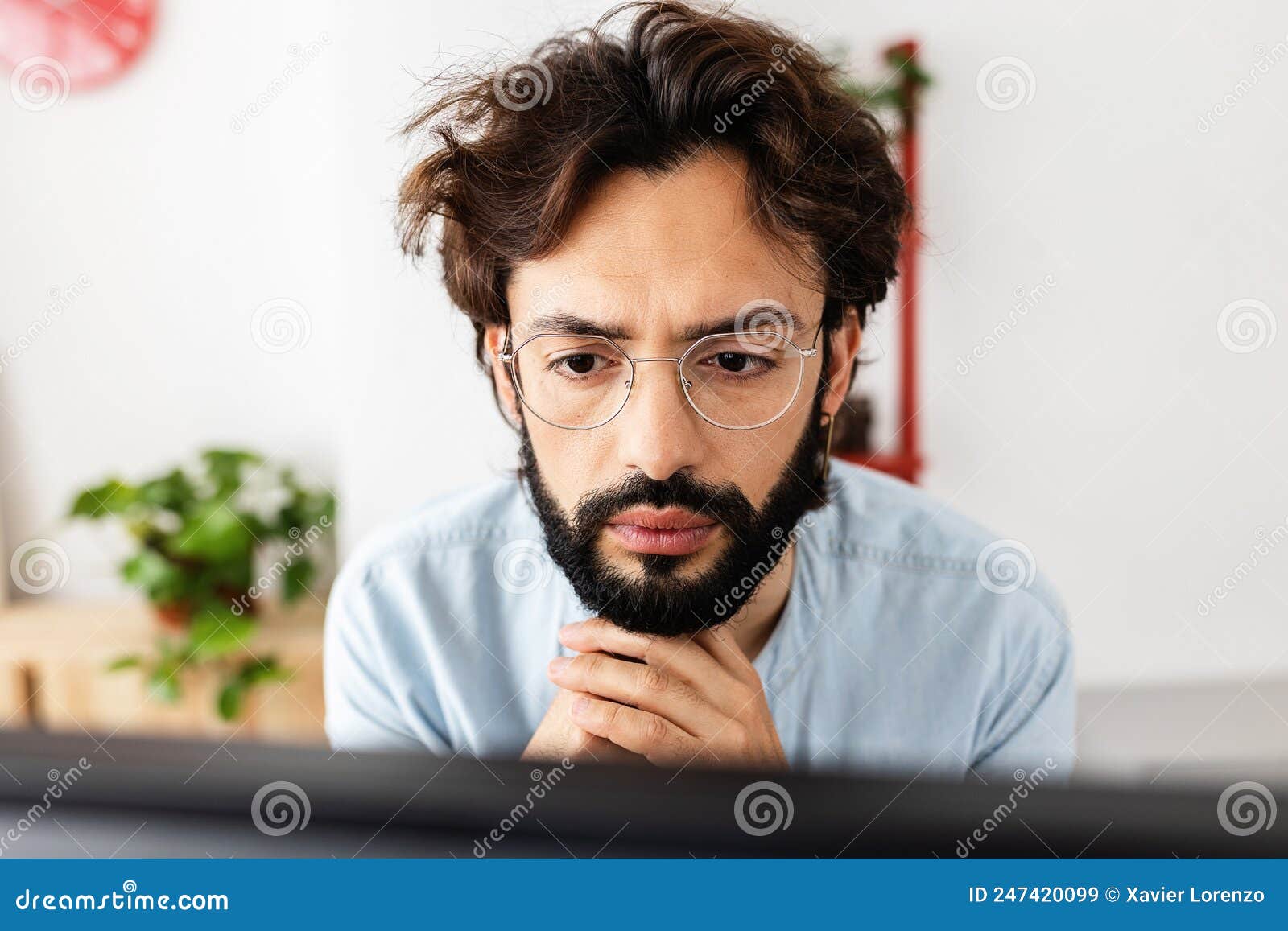Young Bearded Man In Glasses Working Concentrated On Laptop Computer