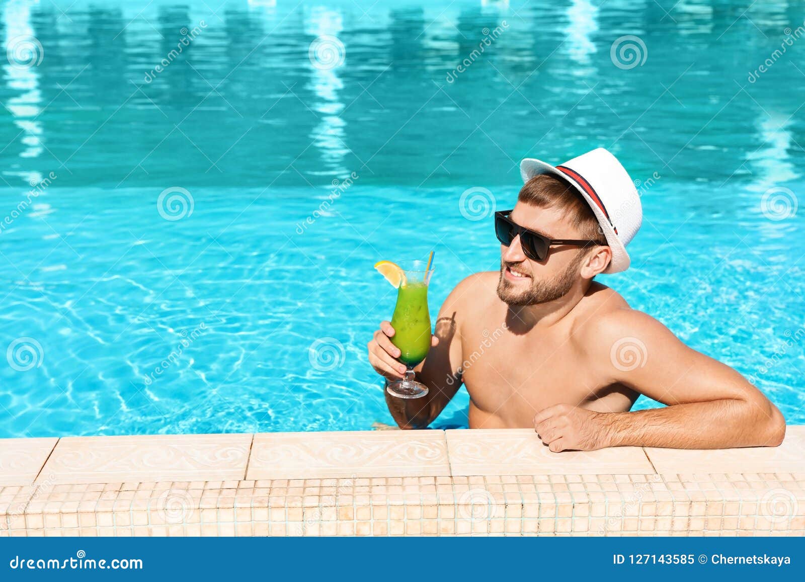 Young Bearded Man with Refreshing Cocktail in Swimming Pool at Resort ...
