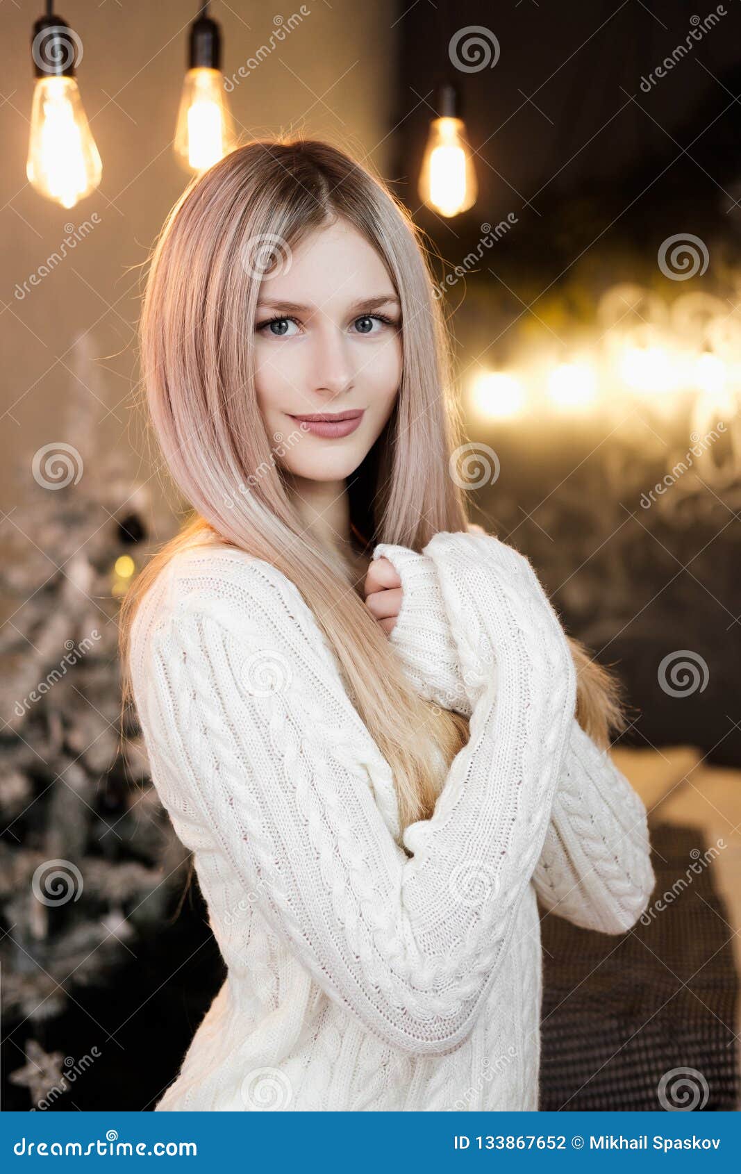 Young Beautiful Blonde Girl In A Warm White Knitted Sweater On The