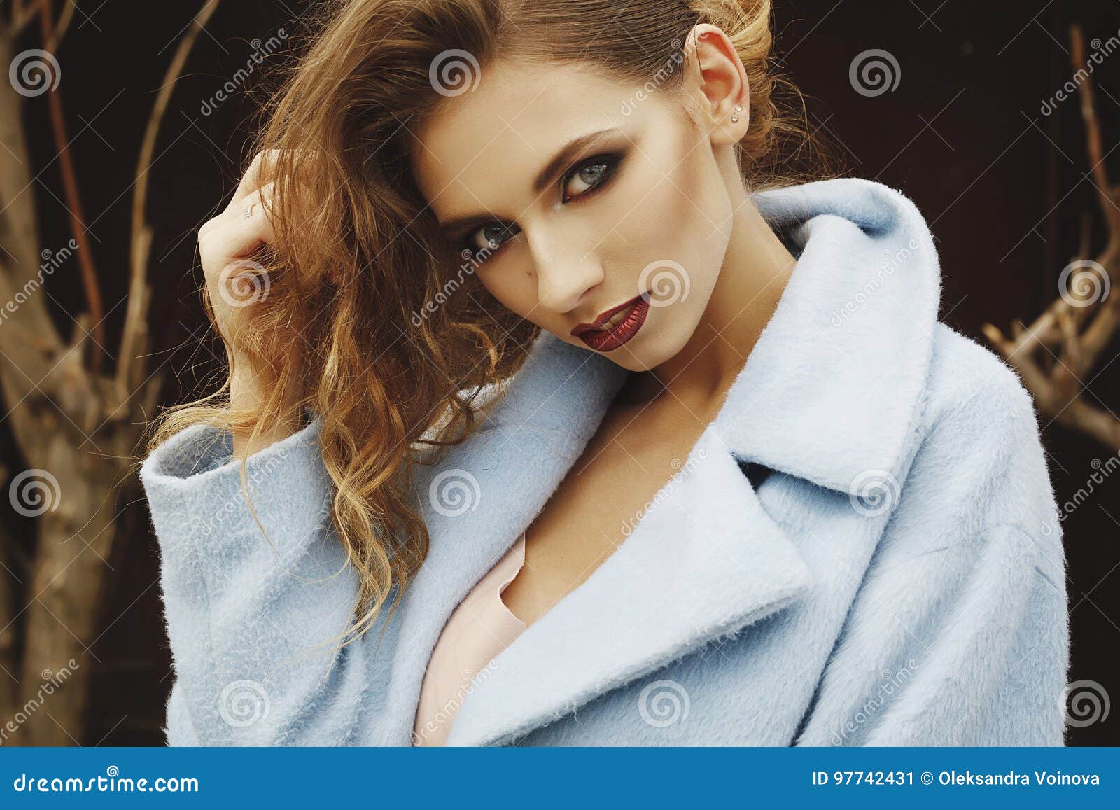 Young Beautiful Blonde Woman Posing In Blue Coat Outdoors Stock Image