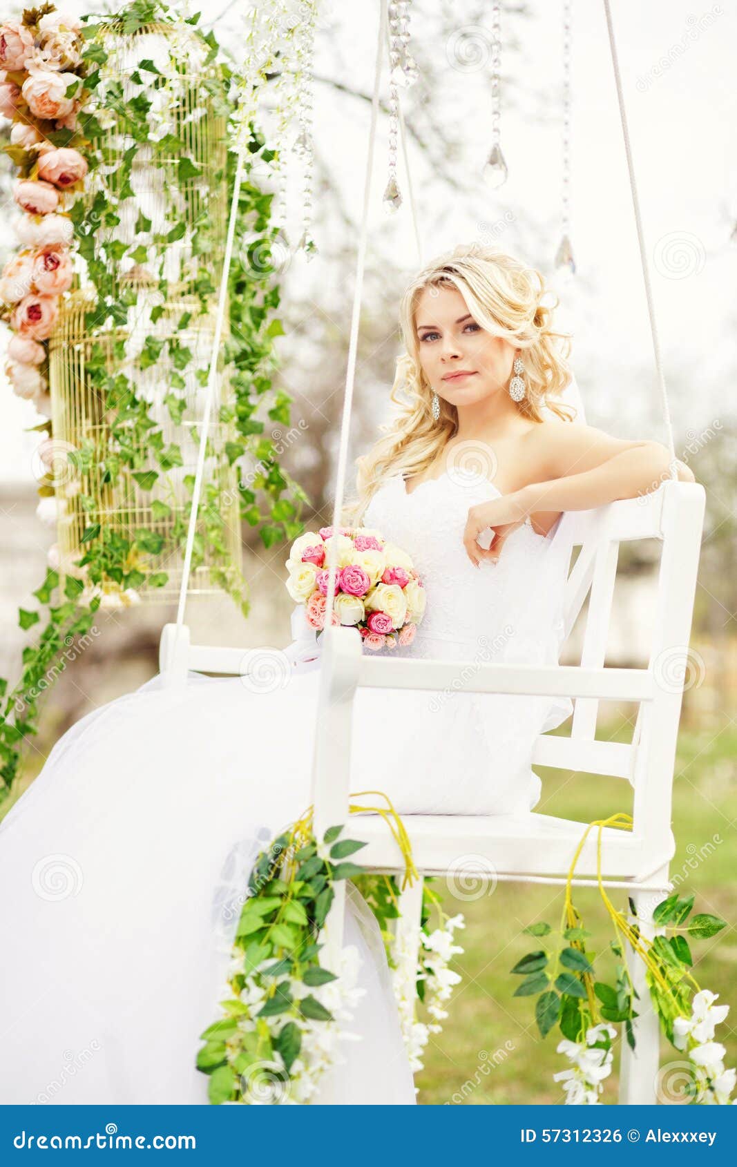Young and Beautiful Bride Sitting on a White Swing in a Spring G Stock ...