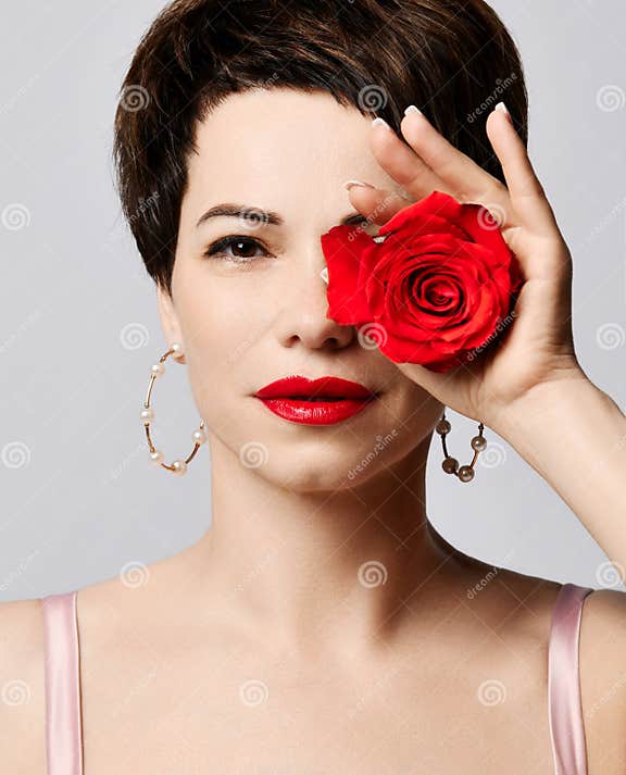 Young Beautiful Brunette Woman With Short Hair In Pink Silk Dress Holds