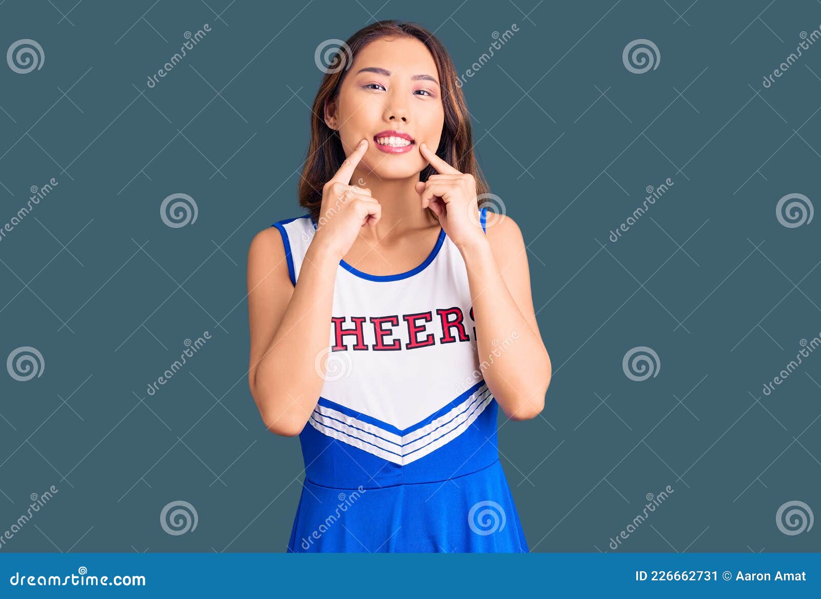 Young Beautiful Chinese Girl Wearing Cheerleader Uniform Smiling With