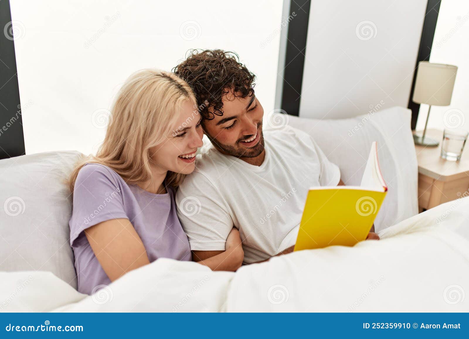 Young Beautiful Couple Reading Book Lying in Bed at Home Stock Photo - Image of love, sheet ...