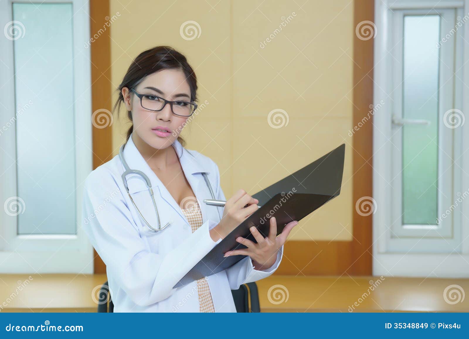Young Beautiful Doctor Writing on Folder Stock Image - Image of ...