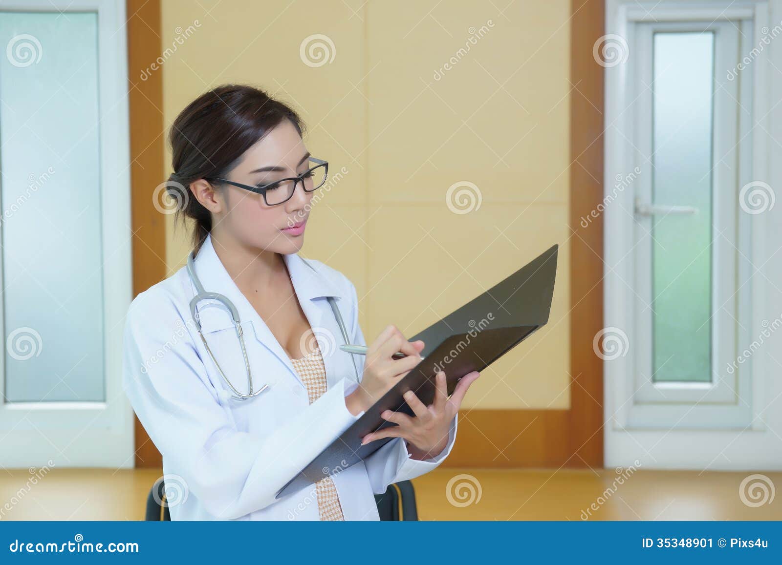 Young Beautiful Doctor Writing on Folder Stock Image - Image of ...