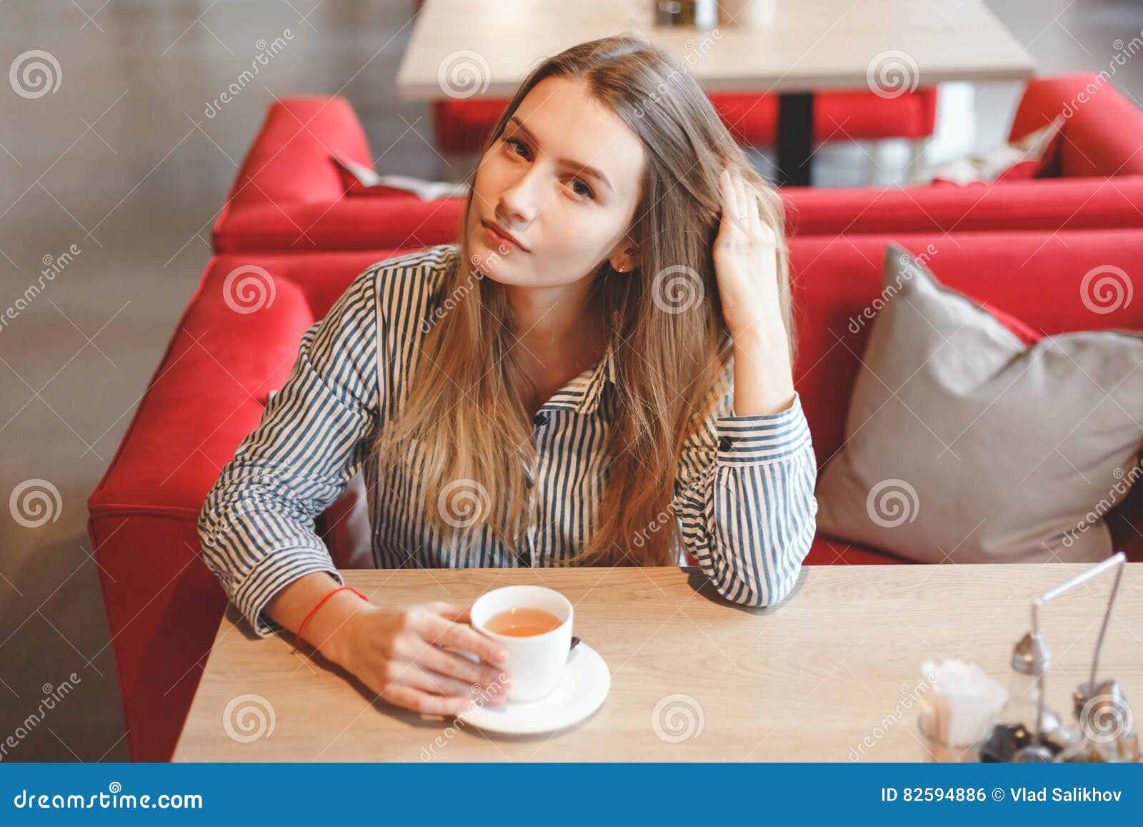 Young Beautiful Flirting Woman Drinks Tea in a Cafe Stock Photo - Image ...