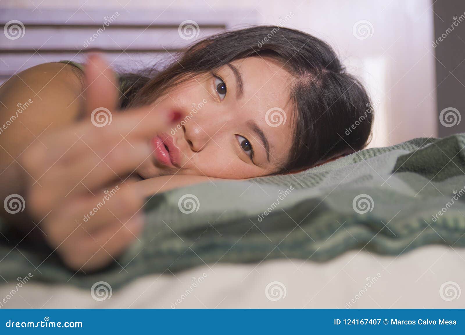 Young Beautiful And Happy Asian Chinese Woman Lying In Bed At Home