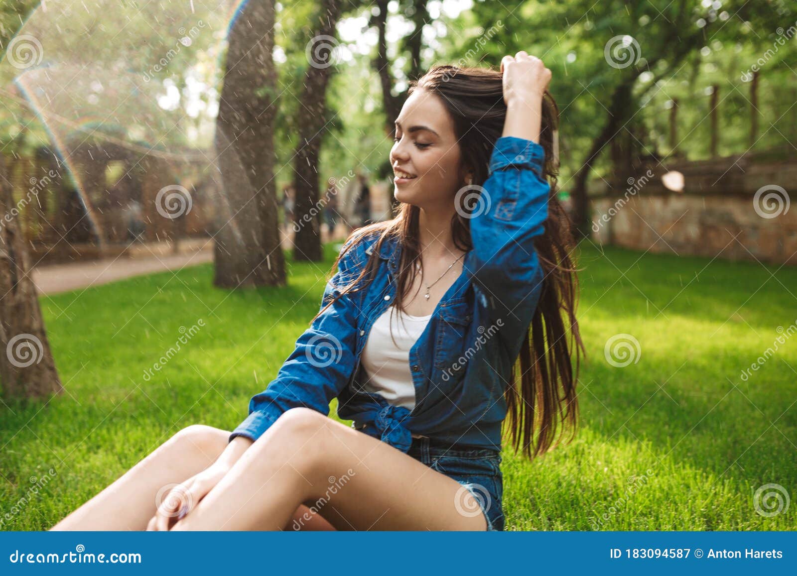 Young Beautiful Happy Lady In Shorts And Denim Shirt Dreamily Closing