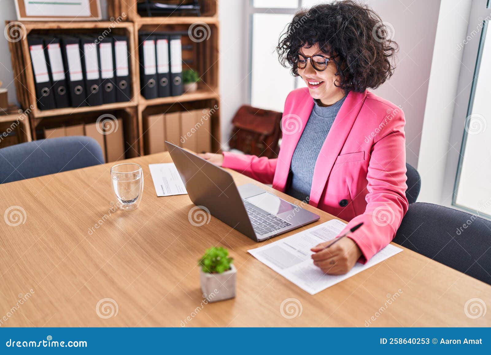 Young Beautiful Hispanic Woman Business Worker Using Laptop Writing on Document at Office Stock ...