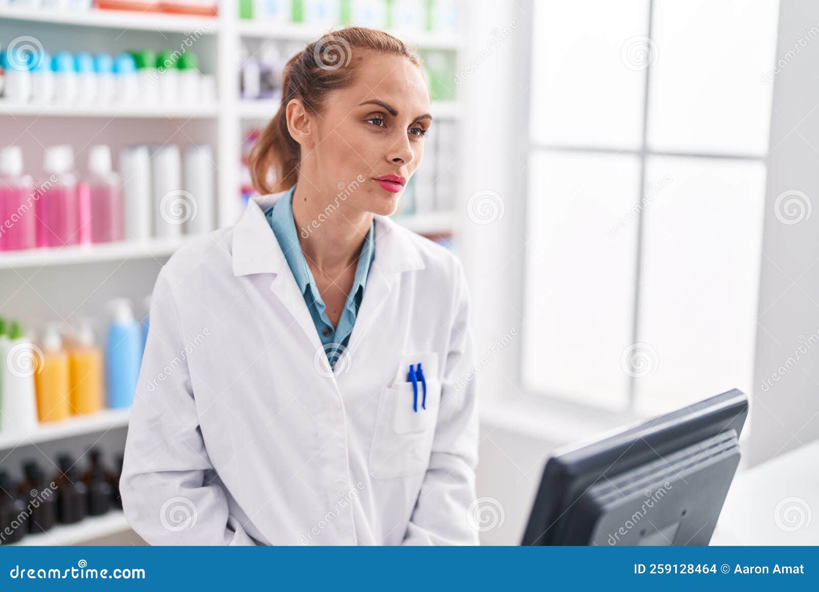 Young Beautiful Hispanic Woman Pharmacist Using Computer with Serious ...