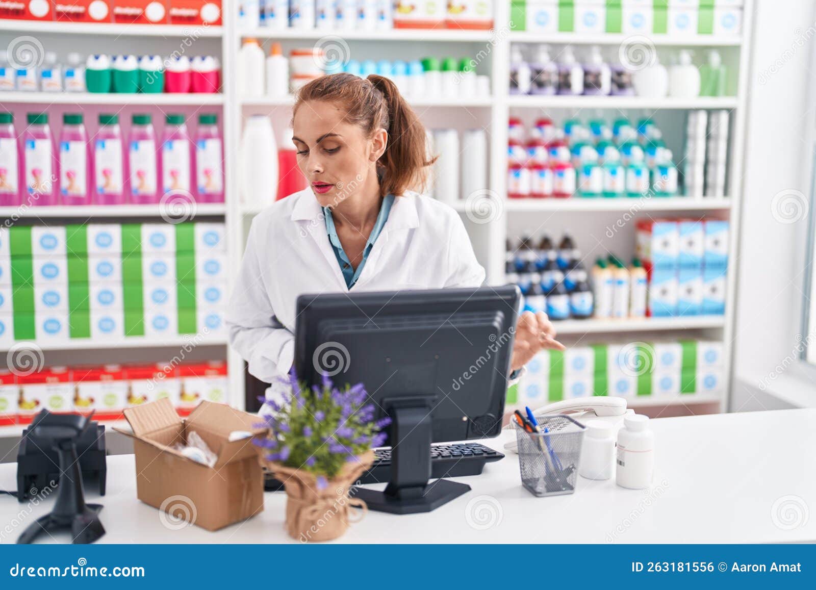 Young Beautiful Hispanic Woman Pharmacist Using Computer Unboxing ...