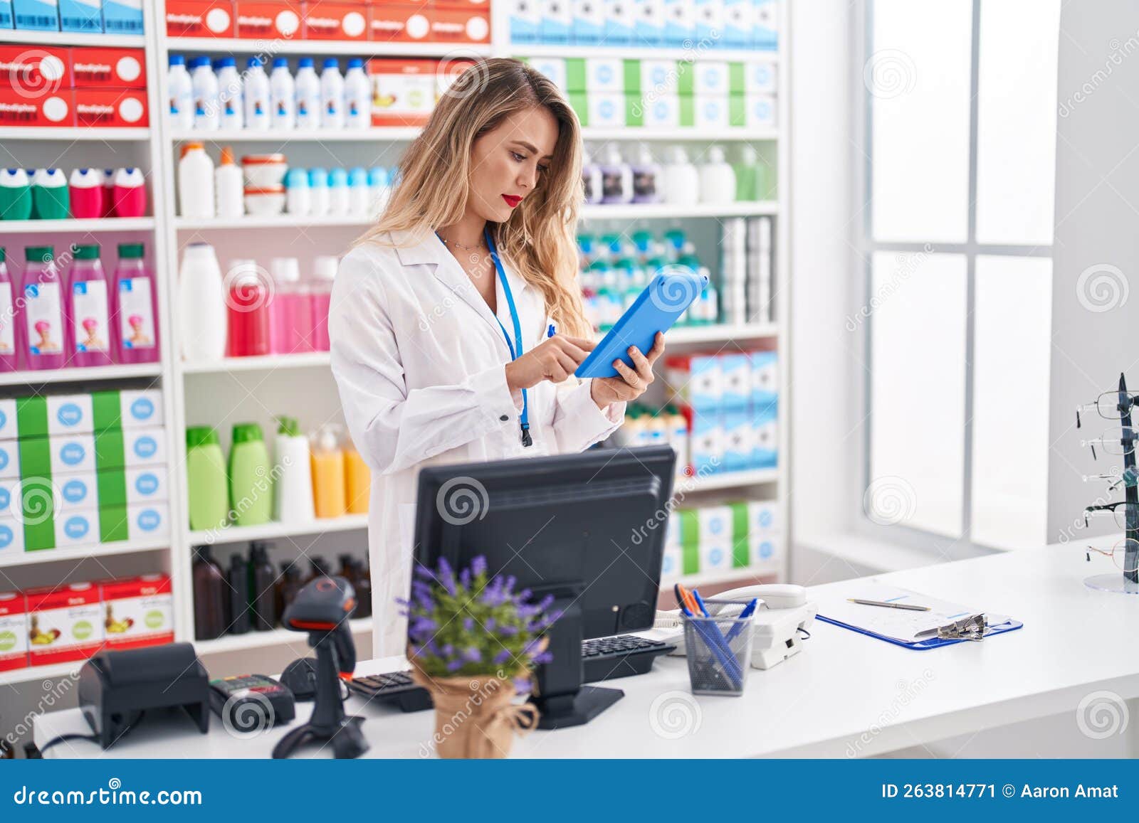 Young Beautiful Hispanic Woman Pharmacist Using Touchpad and Computer ...