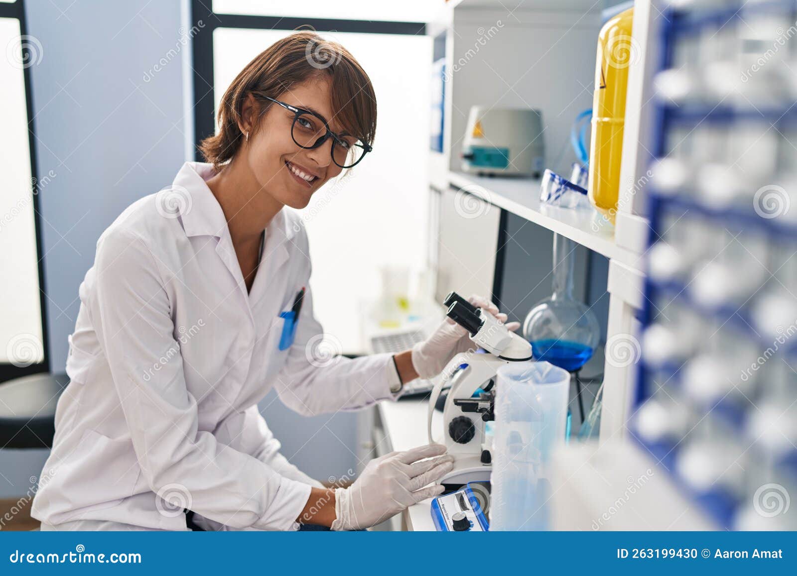 Young Beautiful Hispanic Woman Scientist Using Microscope at Laboratory ...
