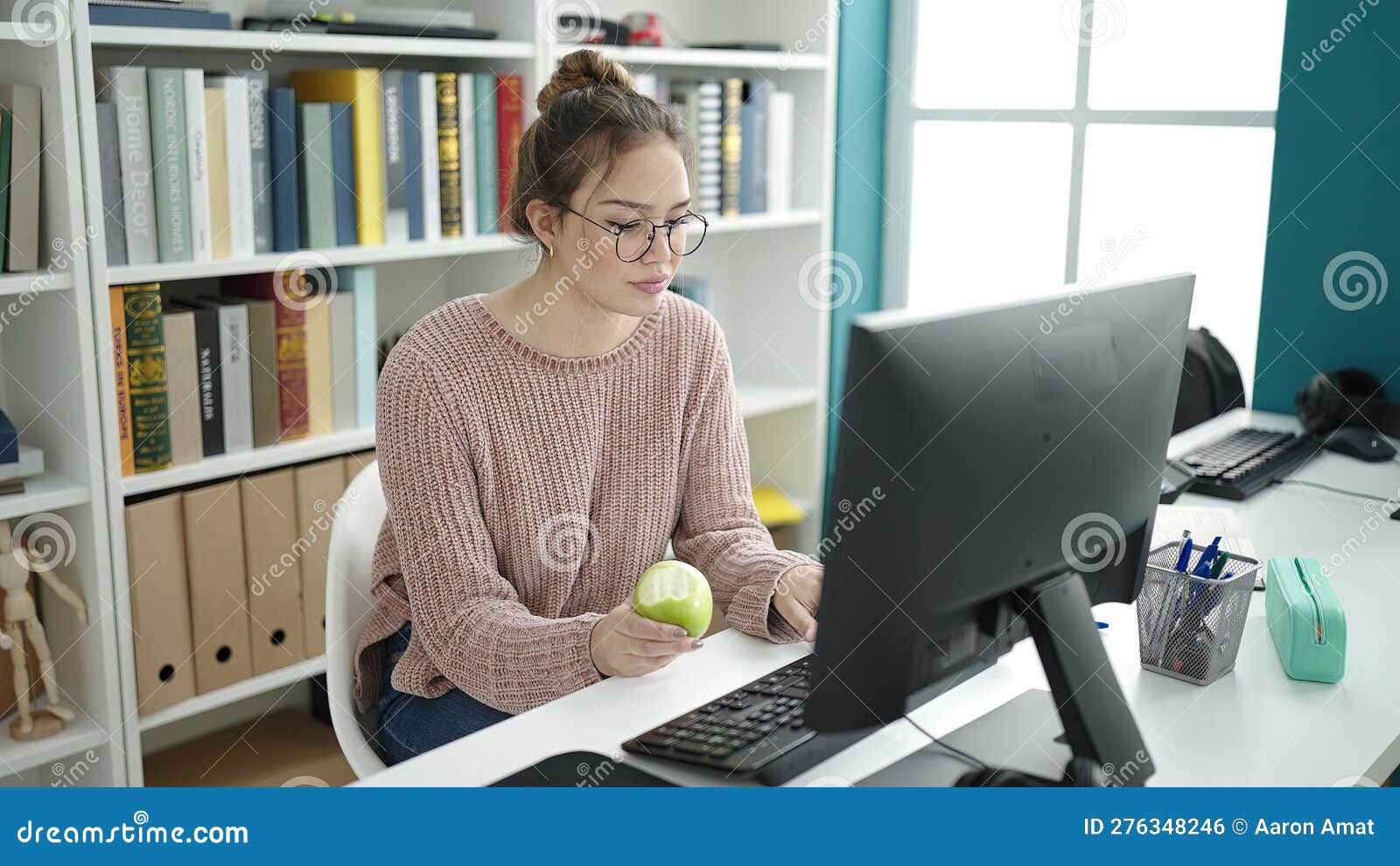Young Beautiful Hispanic Woman Student Using Computer Eating Apple at ...