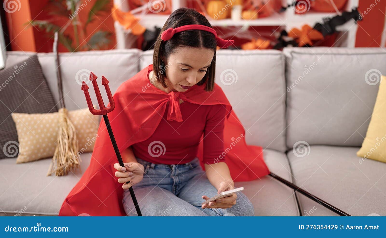 Young Beautiful Hispanic Woman Wearing Devil Costume Using Smartphone ...