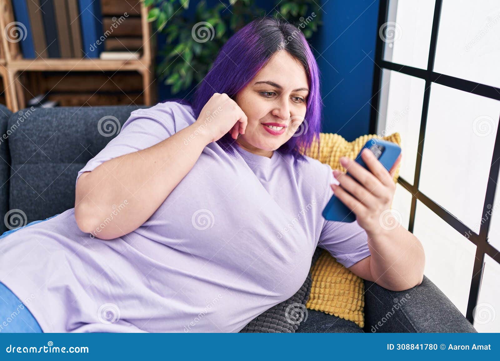 Young Beautiful Plus Size Woman Using Smartphone Lying on Sofa at Home ...