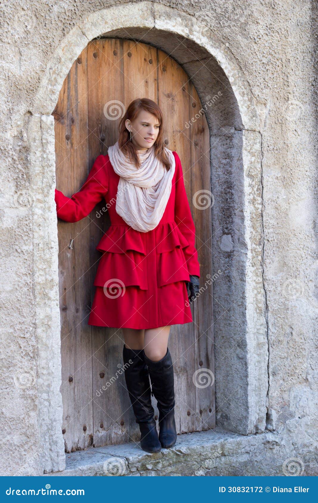 Young Beautiful Redhaired Woman Posing In Front Of The Old Door Stock