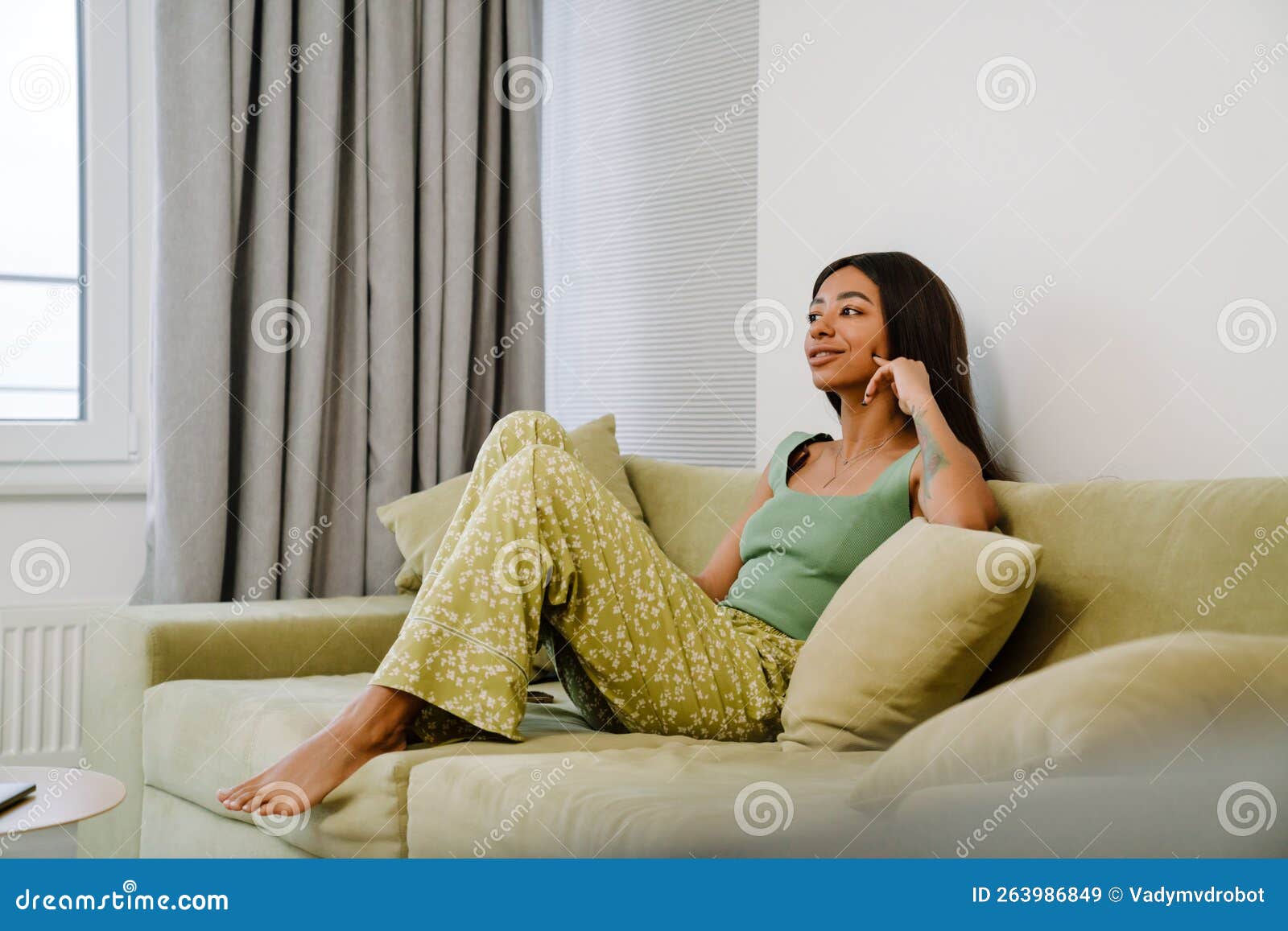Young Beautiful Smiling Long Haired Woman Sitting On Sofa And Relaxing