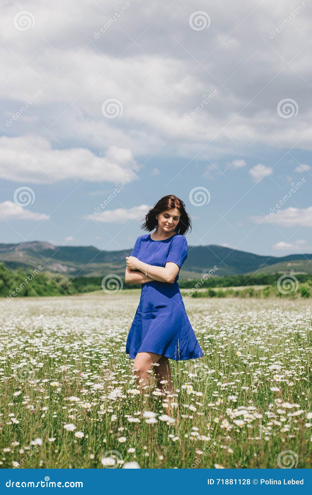 Young Beautiful Woman In A Blue Dress Enjoying Chamomile Field Among