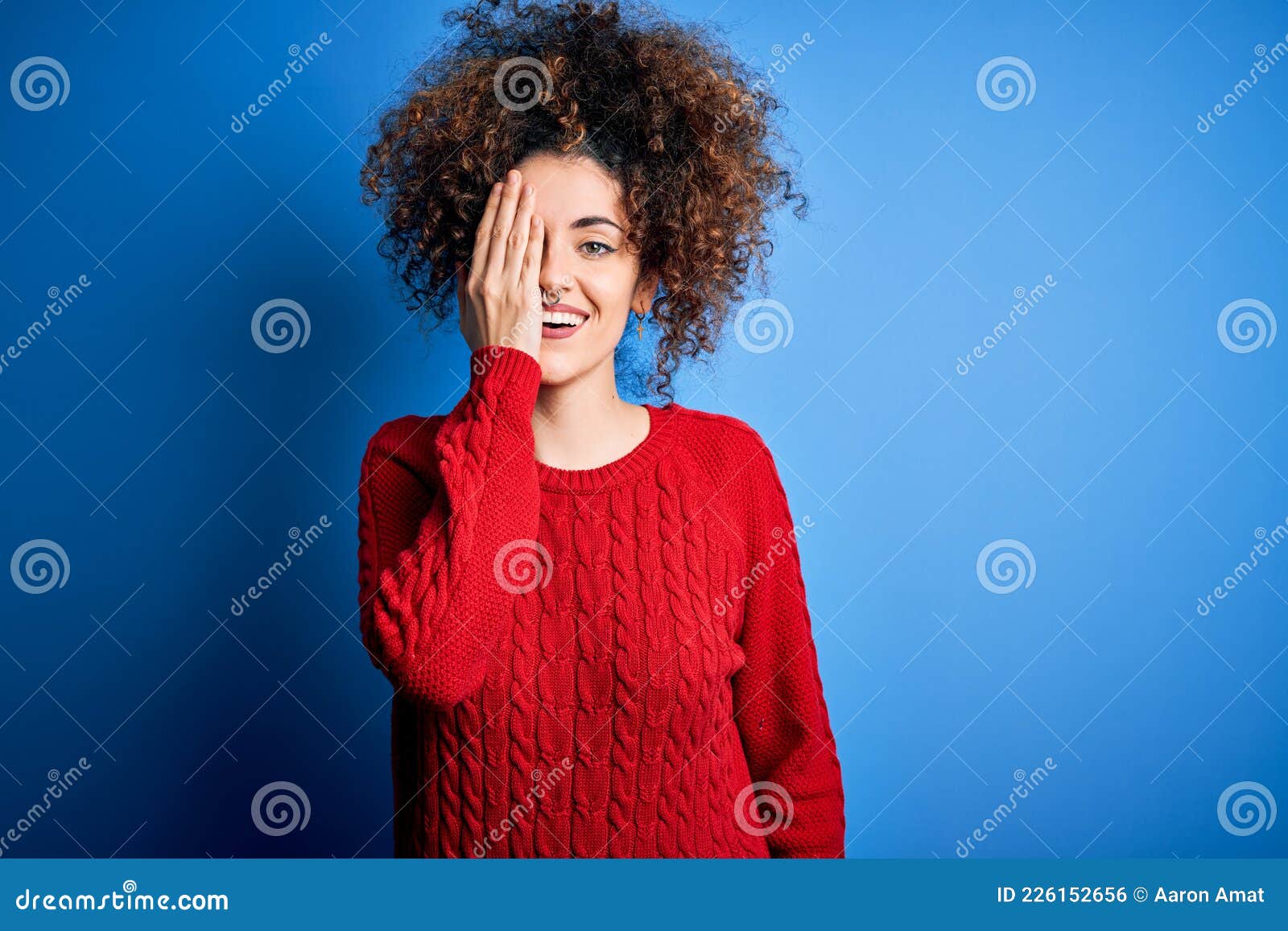 Young Beautiful Woman With Curly Hair And Piercing Wearing Casual Red