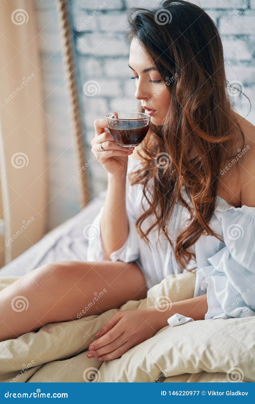 Young Beautiful Woman Drinking Hot Coffee Sitting In Bed And Enjoying