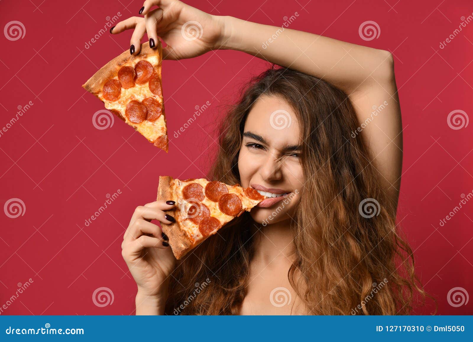 Young Beautiful Woman Eating Slice Of Pepperoni Pizza On Pink Red Stock