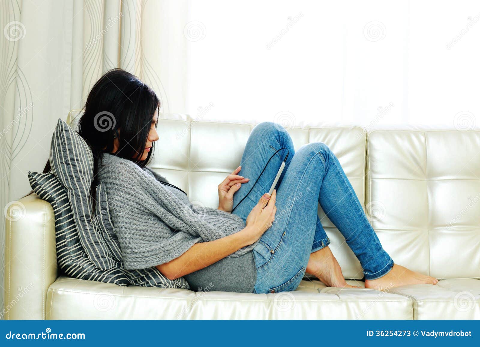 Young Beautiful Woman Resting on a Sofa with Tablet Computer Stock ...