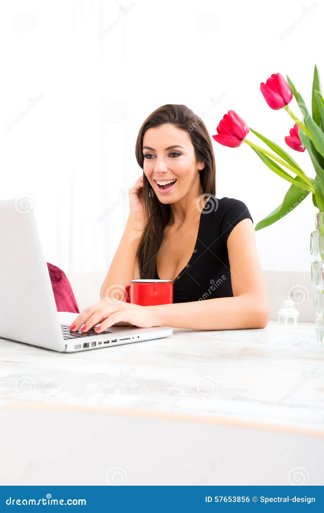 Young Beautiful Woman Smiling while Using a Laptop at Home Stock Photo ...