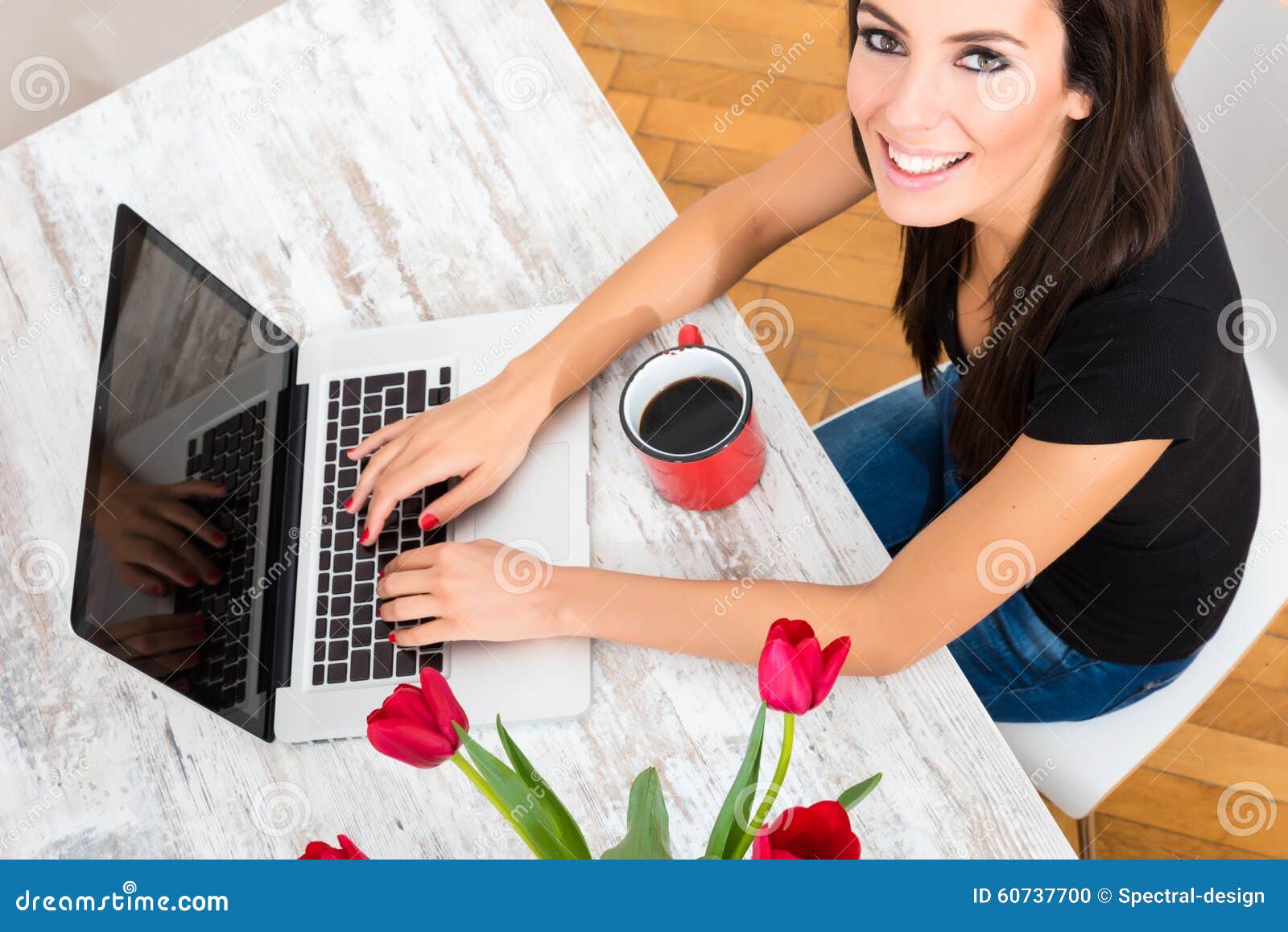 Young Beautiful Woman Smiling while Using a Laptop at Home Stock Photo ...