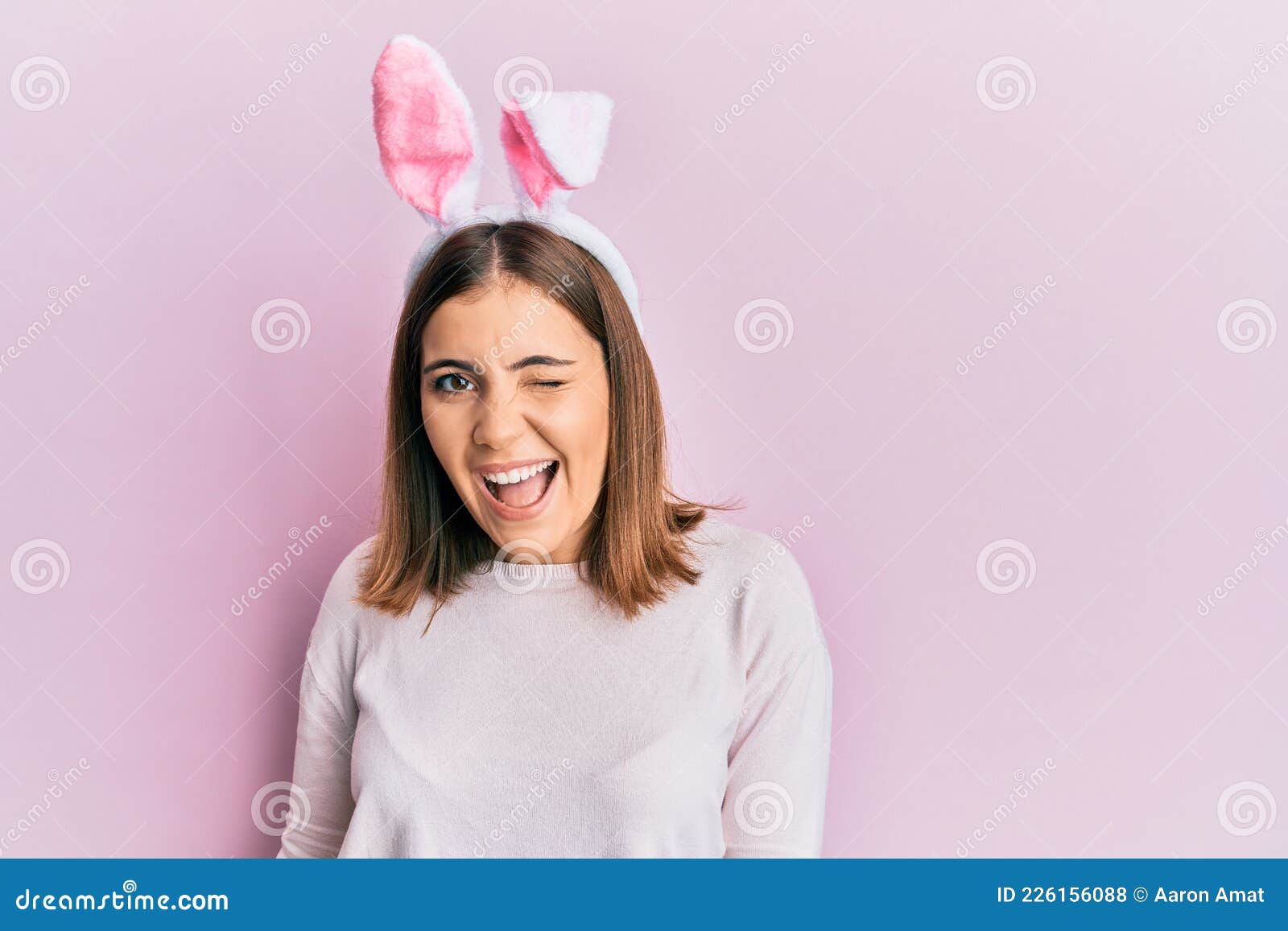 Young Beautiful Woman Wearing Cute Easter Bunny Ears Winking Looking At