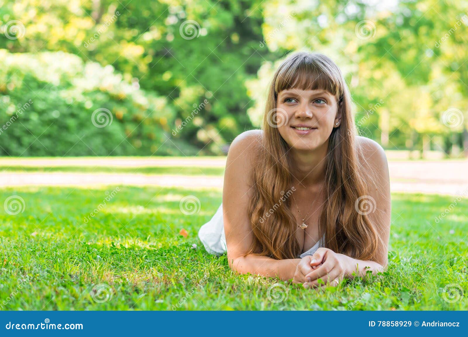 Young Beautiful Woman In White Dress Lying On The Grass Stock Image