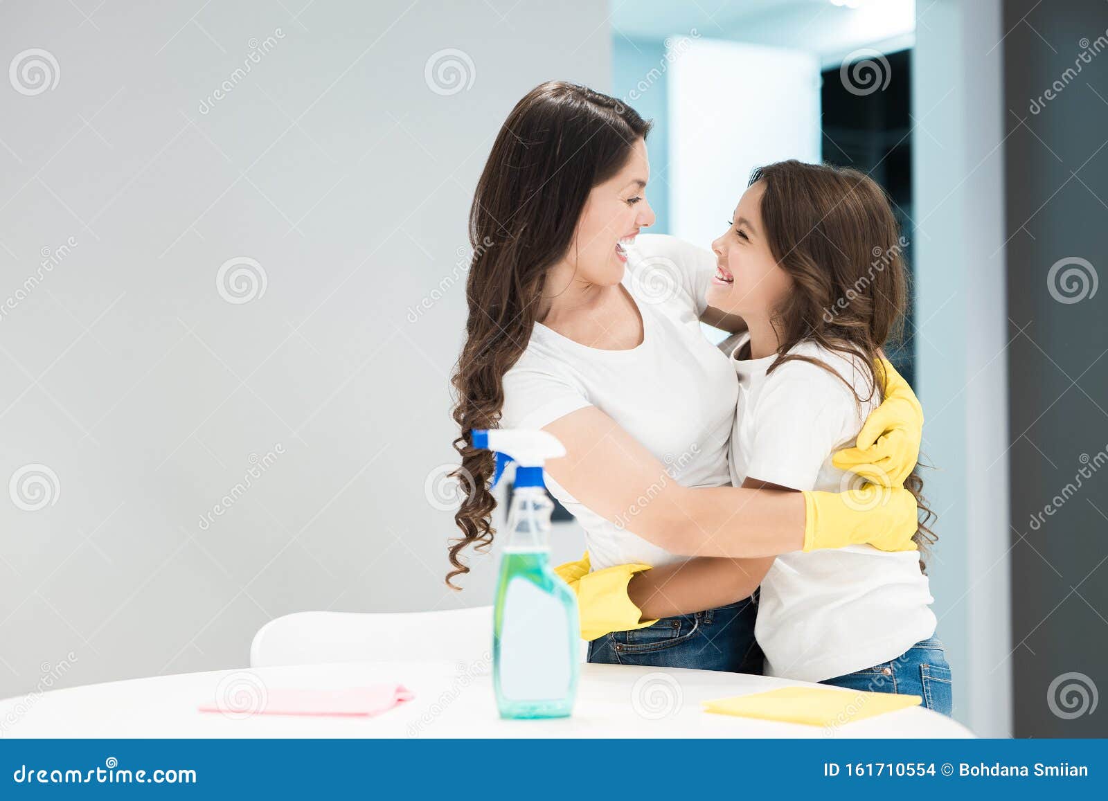 Young Beautiful Woman Hugging Her Cute Teen Daughter In Yellow Gloves