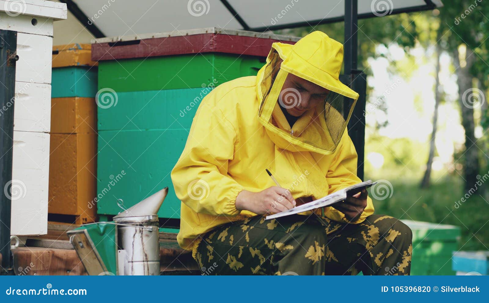 Young Beekeeper Man Write in Notepad Checking Harvest while Sitting ...