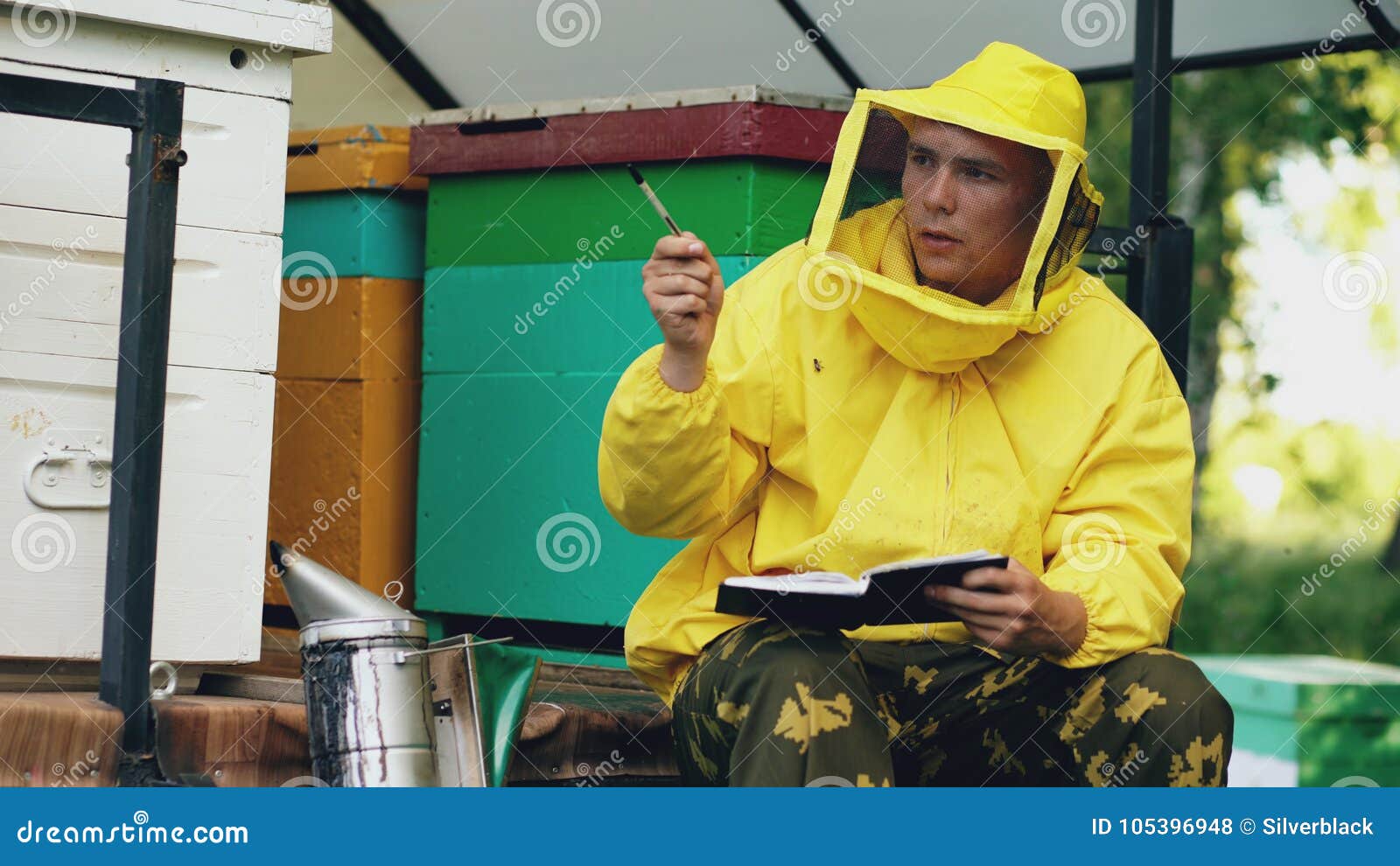 Young Beekeeper Man Write in Notepad Checking Harvest while Sitting ...